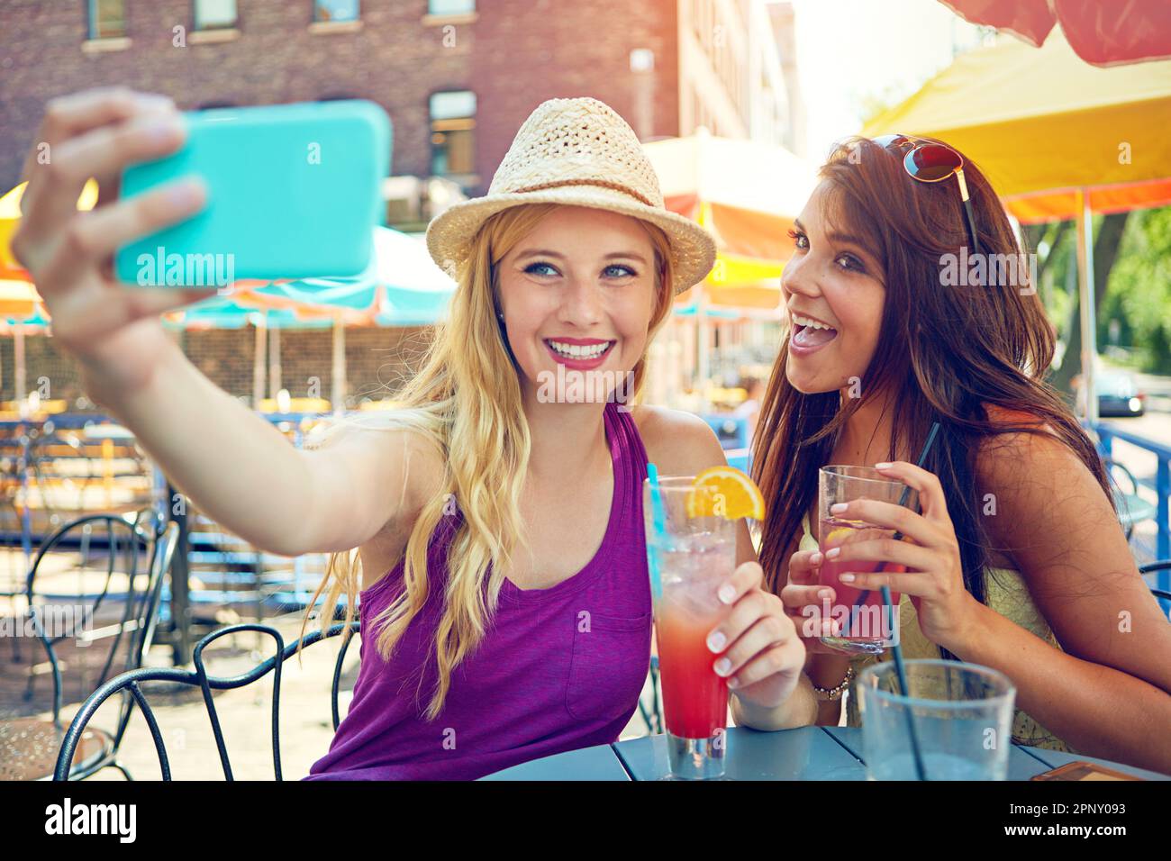Selfies With My Bestie Two Attractive Young Women Taking A Selfie While Sitting At An Outdoor