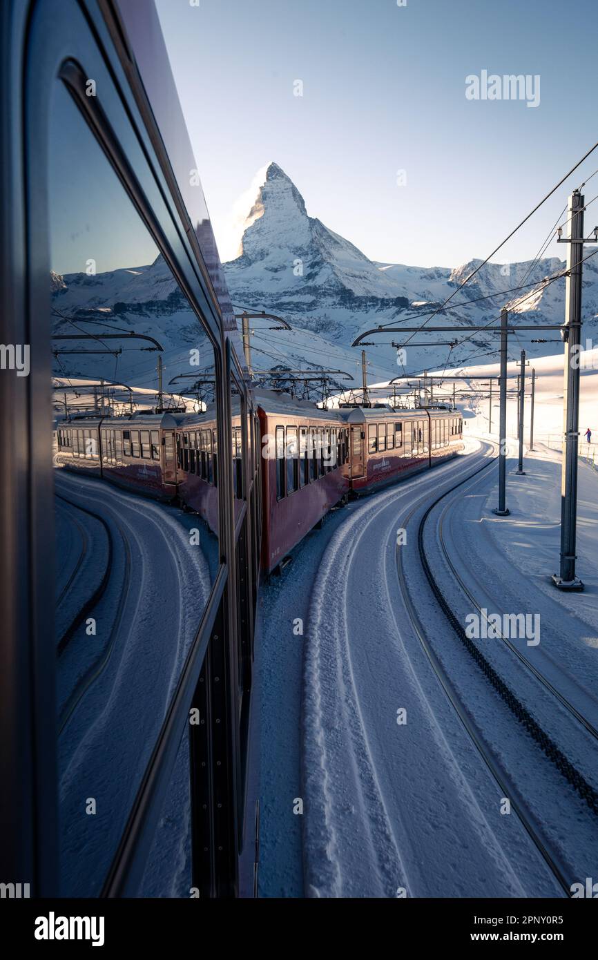 Red train going up a mountain in winter ,matterhorn in background Stock ...
