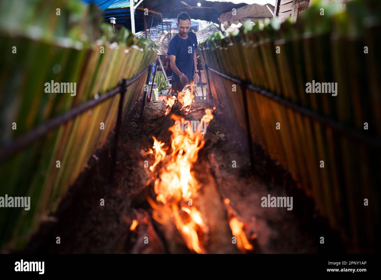 A Malaysian Muslim vendor cooks "lemang," a traditional food of ...