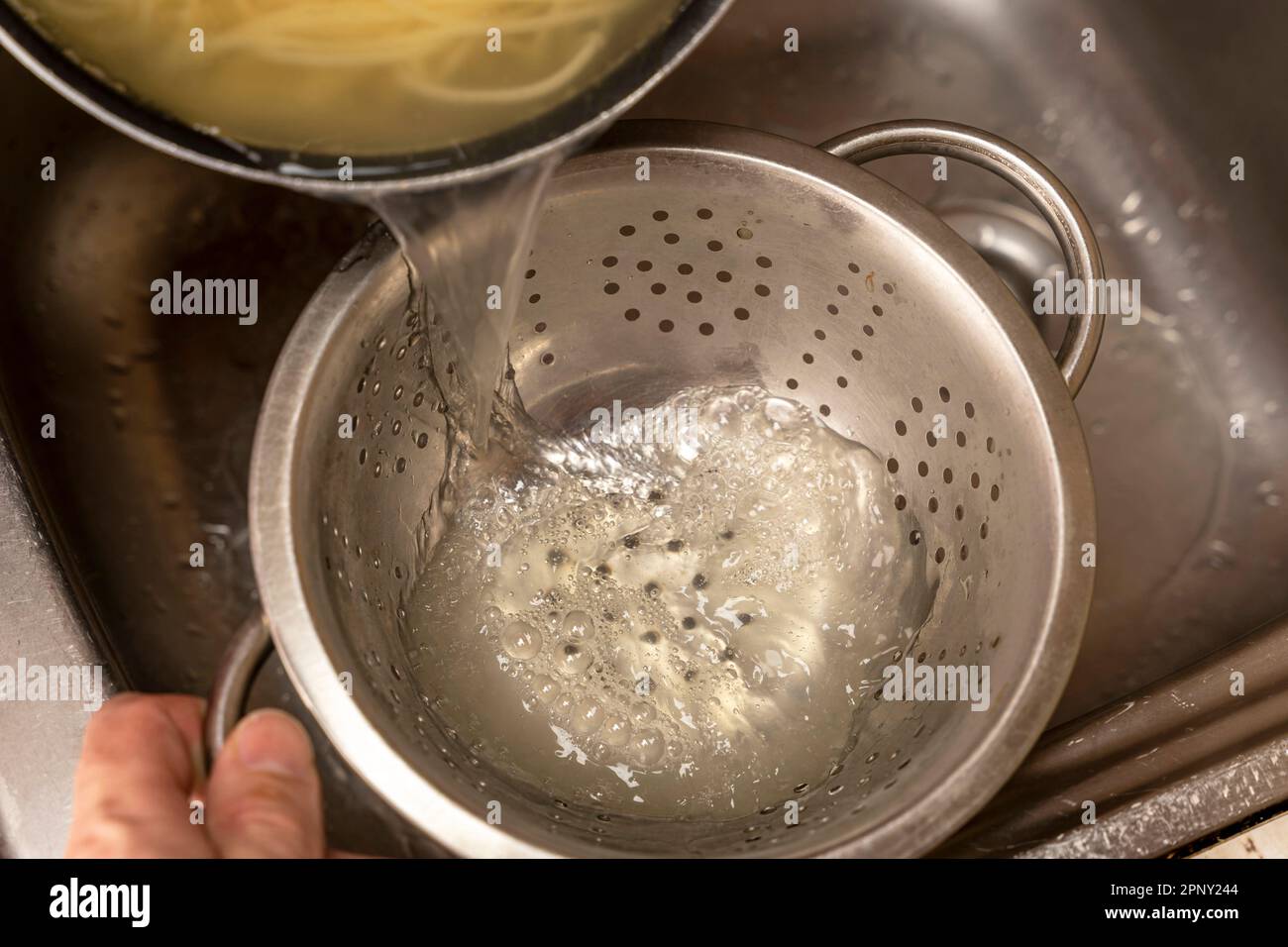 Colander with fresh cooked spaghetti in kitchen Stock Photo - Alamy