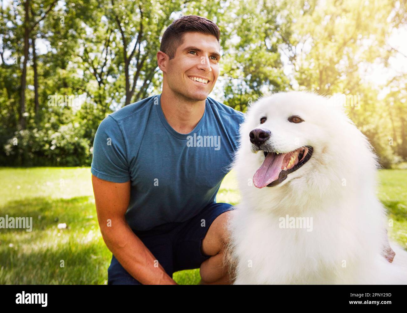 Hes a proud owner. a handsome young man walking his dog in the park ...