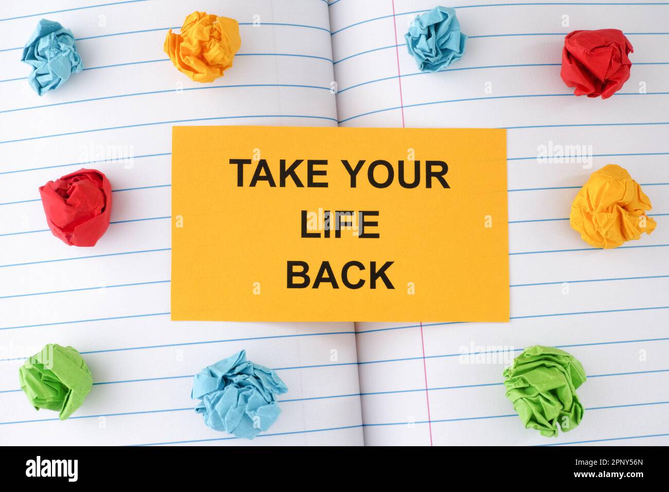 A yellow paper note with the words Take Your Life Back on notebook ...