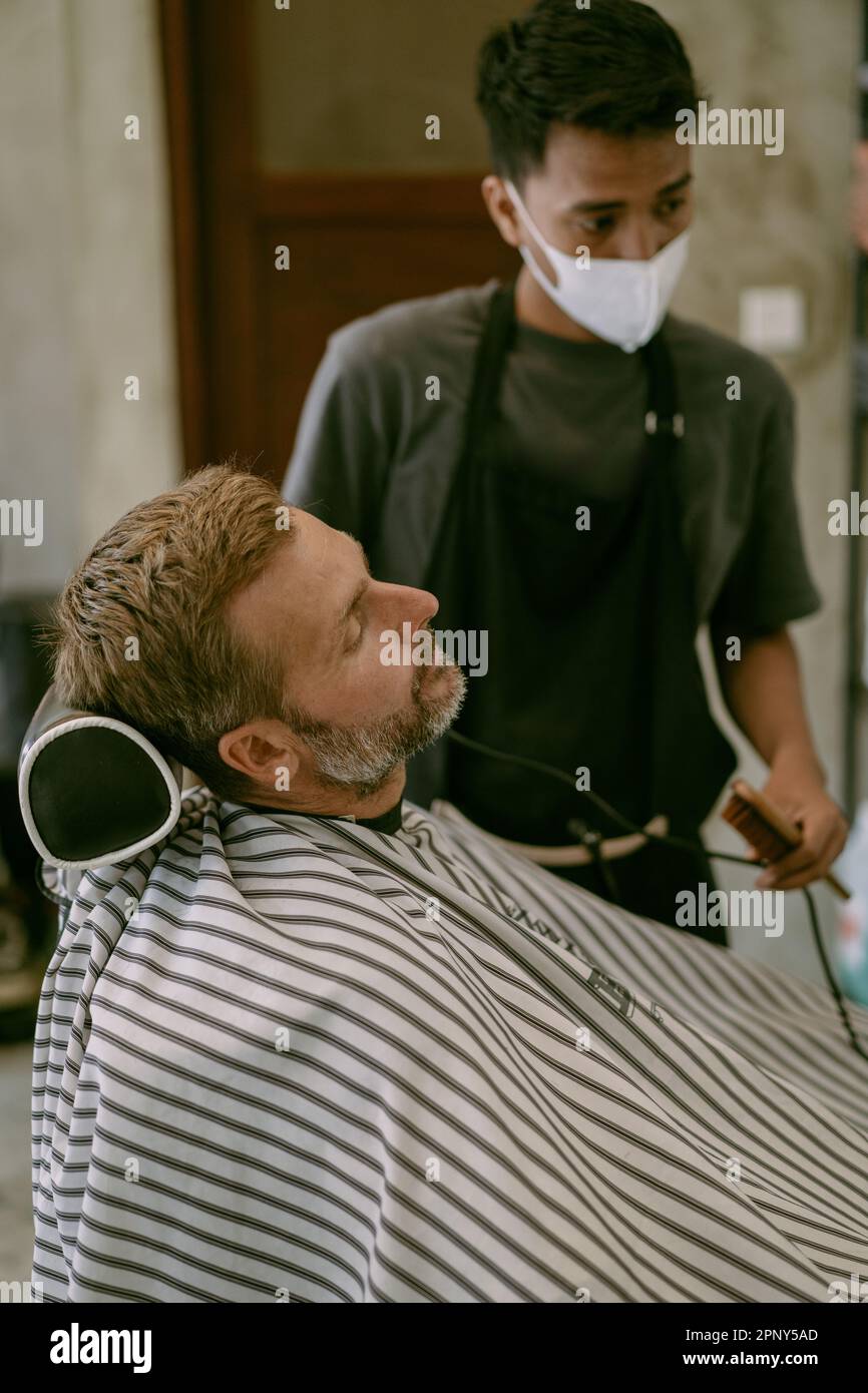 Man in barbershop shaving beard. Beard care Stock Photo - Alamy
