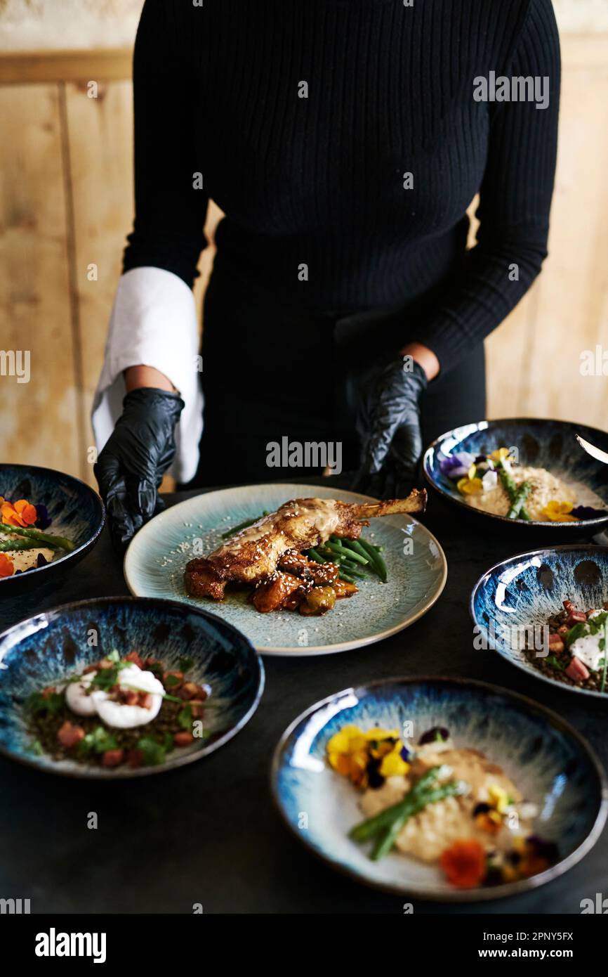 Young lady arranging plates in a delicious catering setup Stock Photo ...