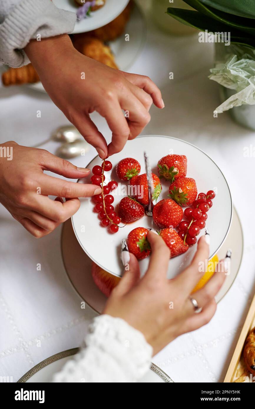 Hands helping themselves to delicious looking fruit platter Stock Photo ...