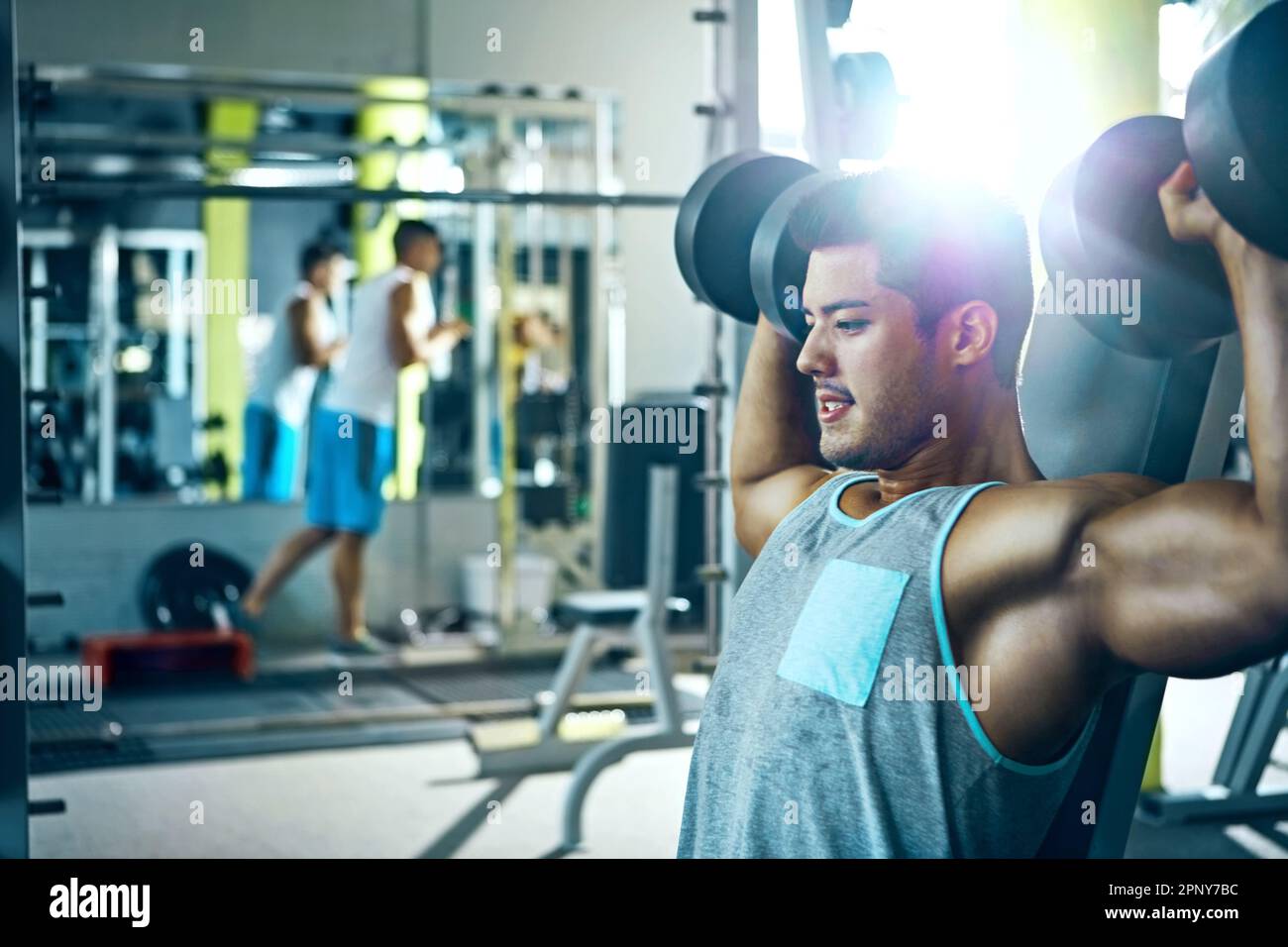 You can do it. a man doing a upper-body workout at the gym Stock Photo ...