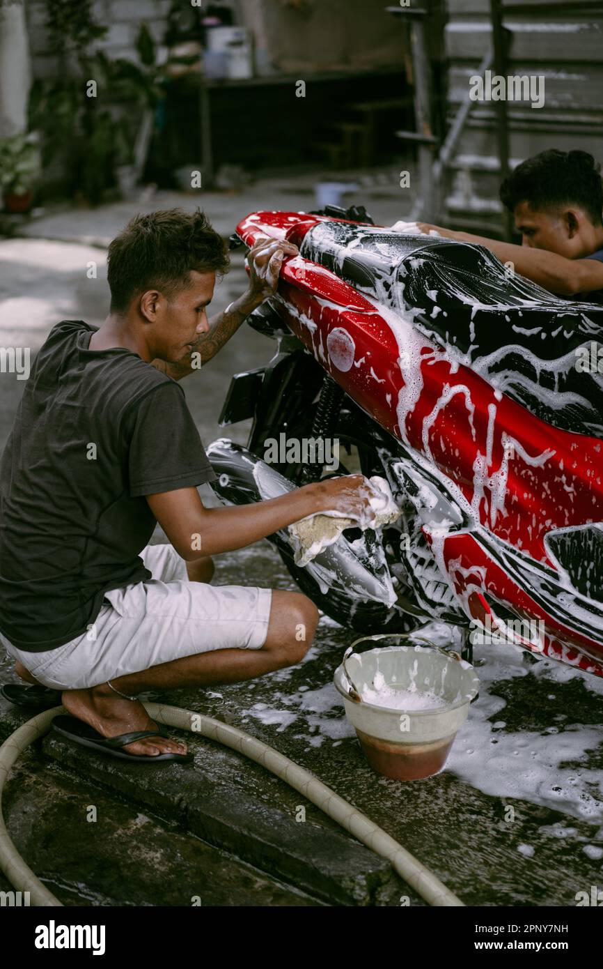 Asian man washing motorbike with soap at service station Stock Photo ...