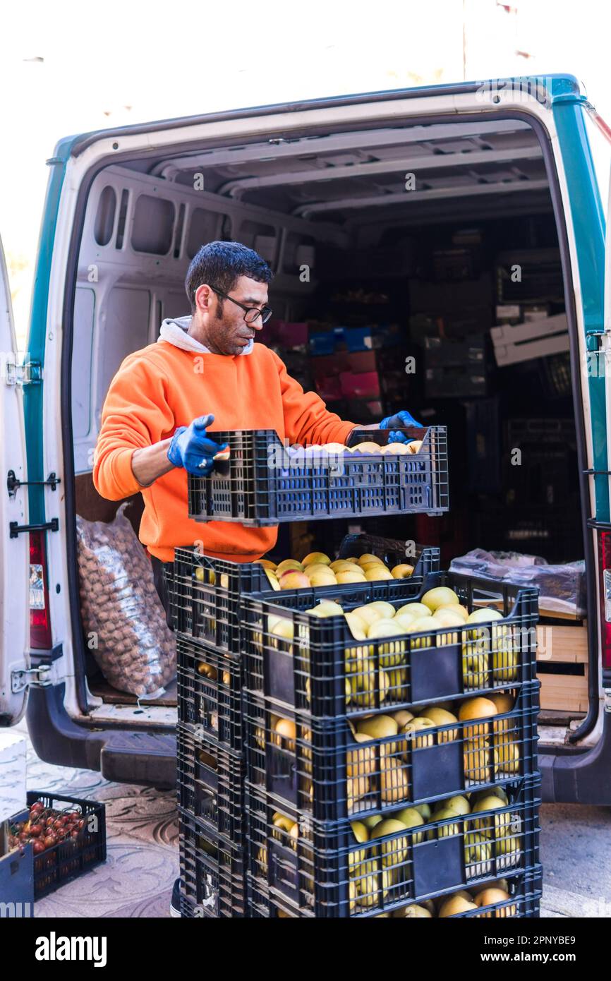 arab man taking boxes of fruit from the van Stock Photo - Alamy