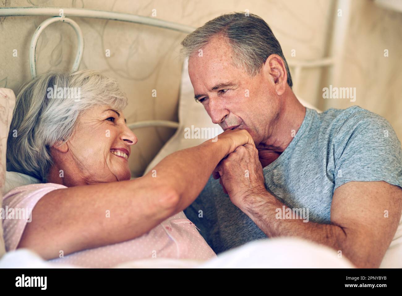 Time has no effect on true romance. a senior couple being affectionate in their bedroom Stock ...