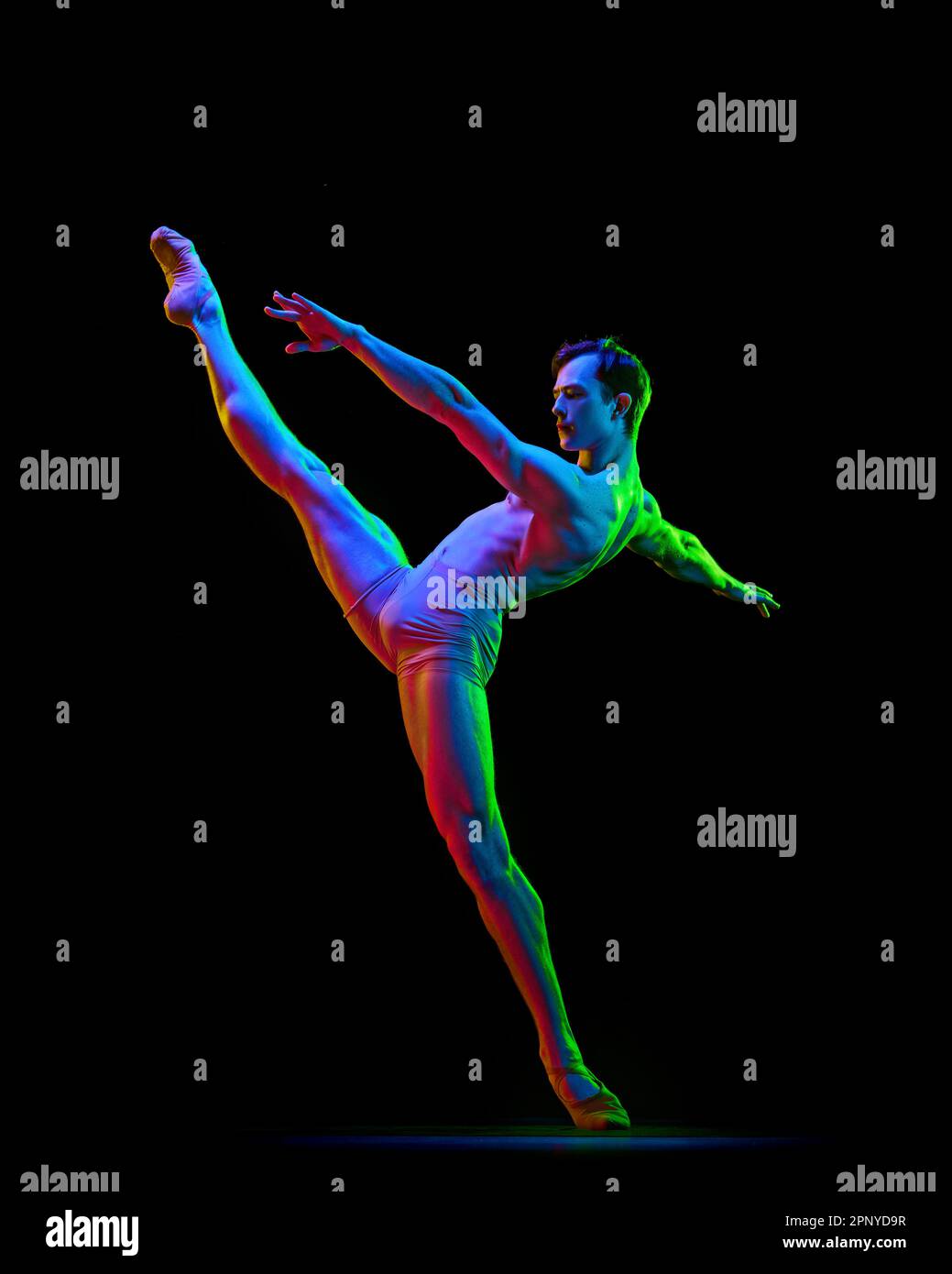 Portrait of graceful muscled male ballet dancer dancing over dark ...