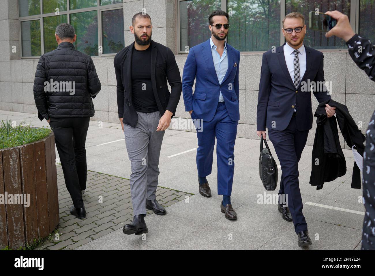 Andrew Tate, left, and his brother Tristan, centre, arrive at the ...
