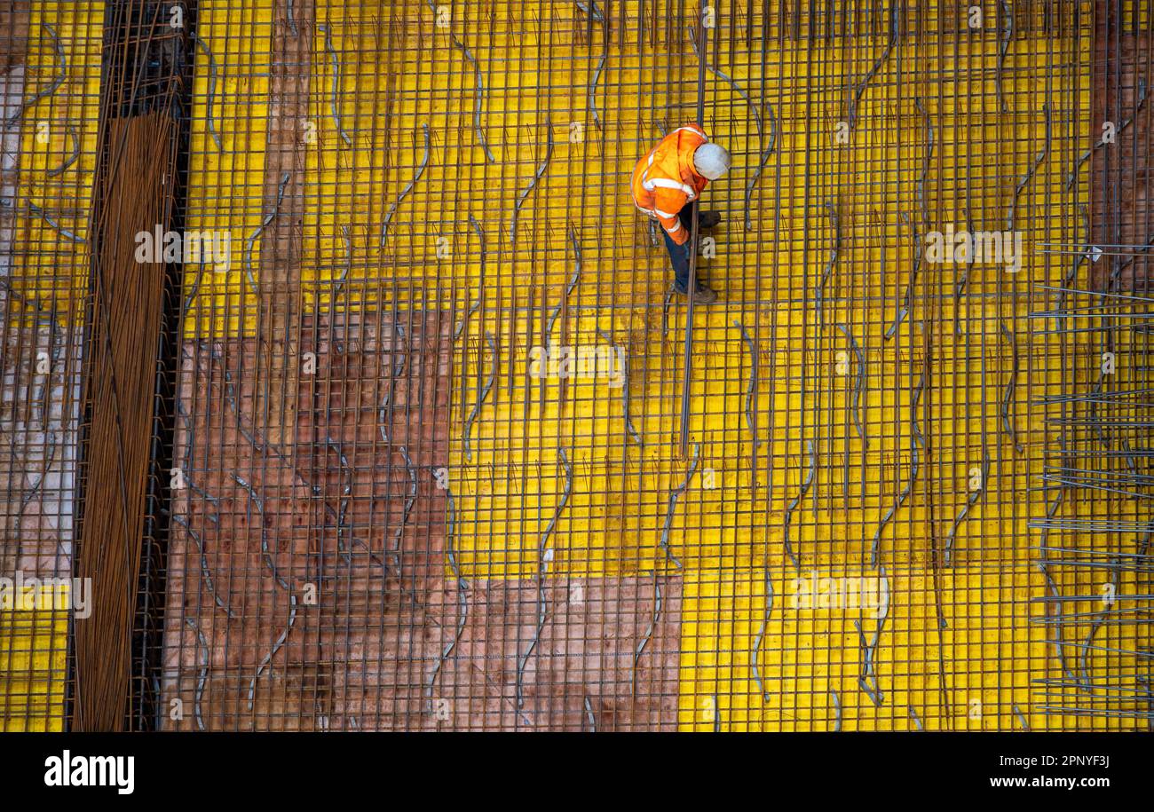 Top view of workers preparing a concrete foundation plate at a ...