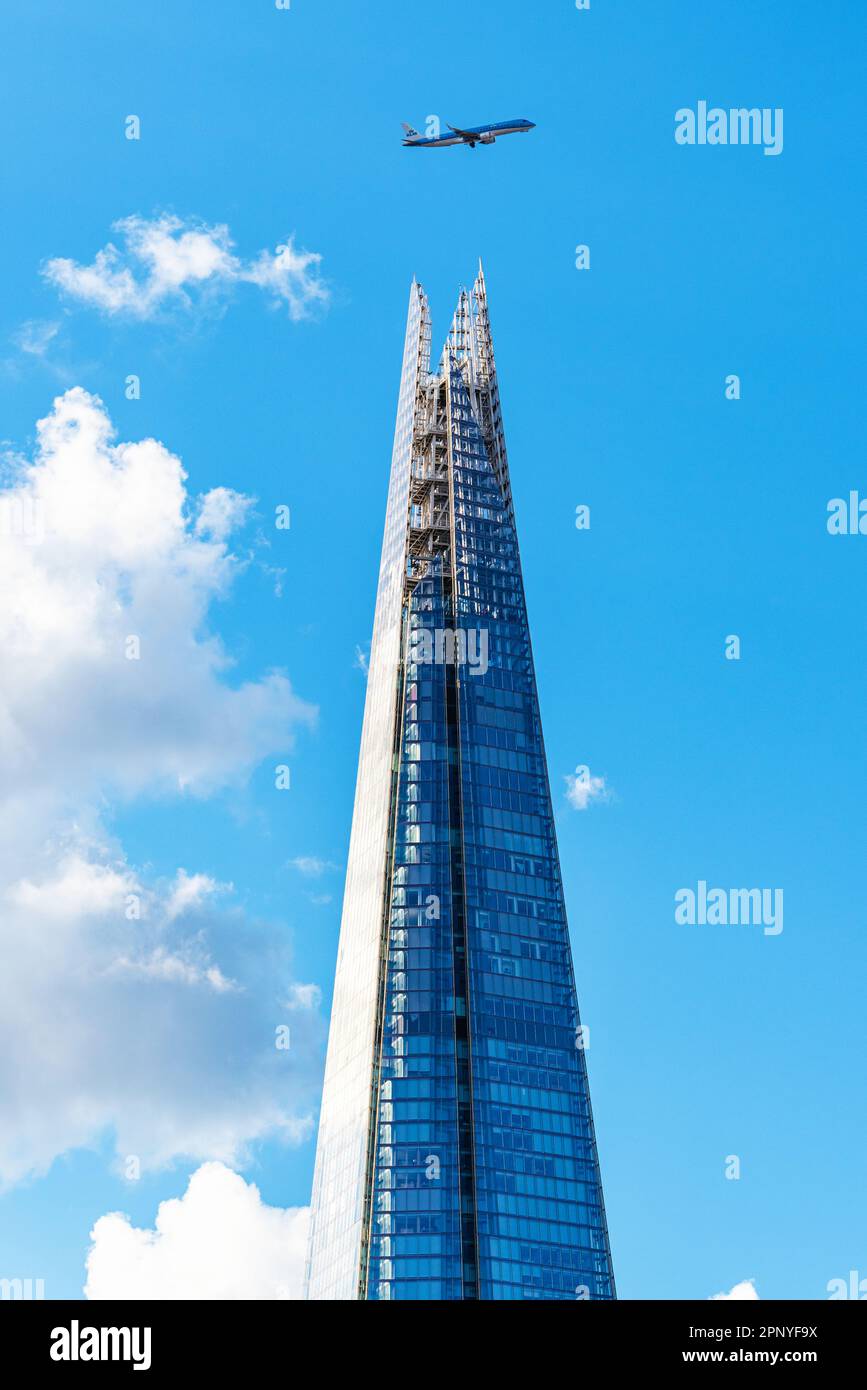 Airplane over a glass skyscraper, The Shard, City of London, England ...