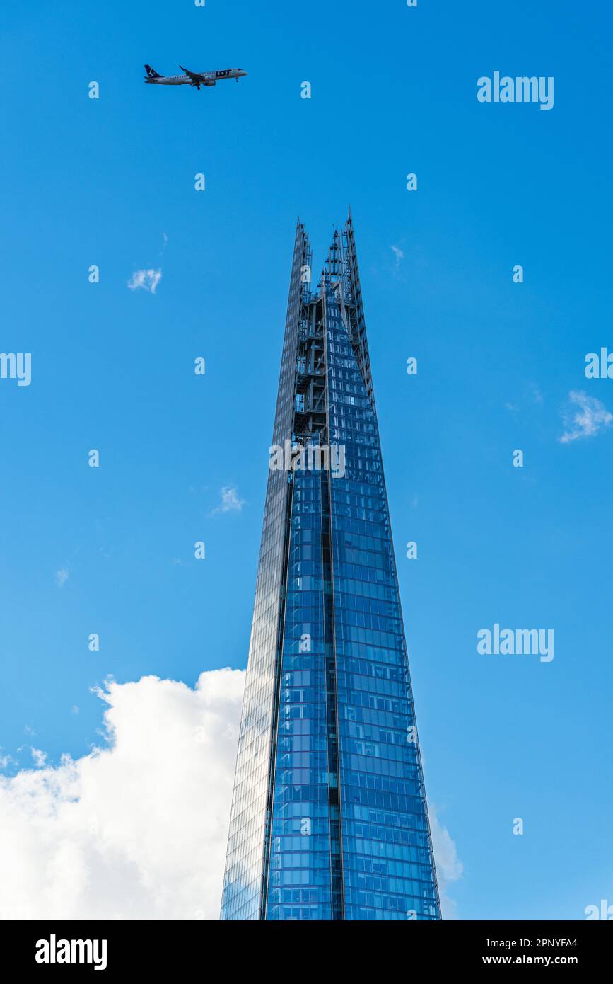 Airplane over a glass skyscraper, The Shard, City of London, England ...