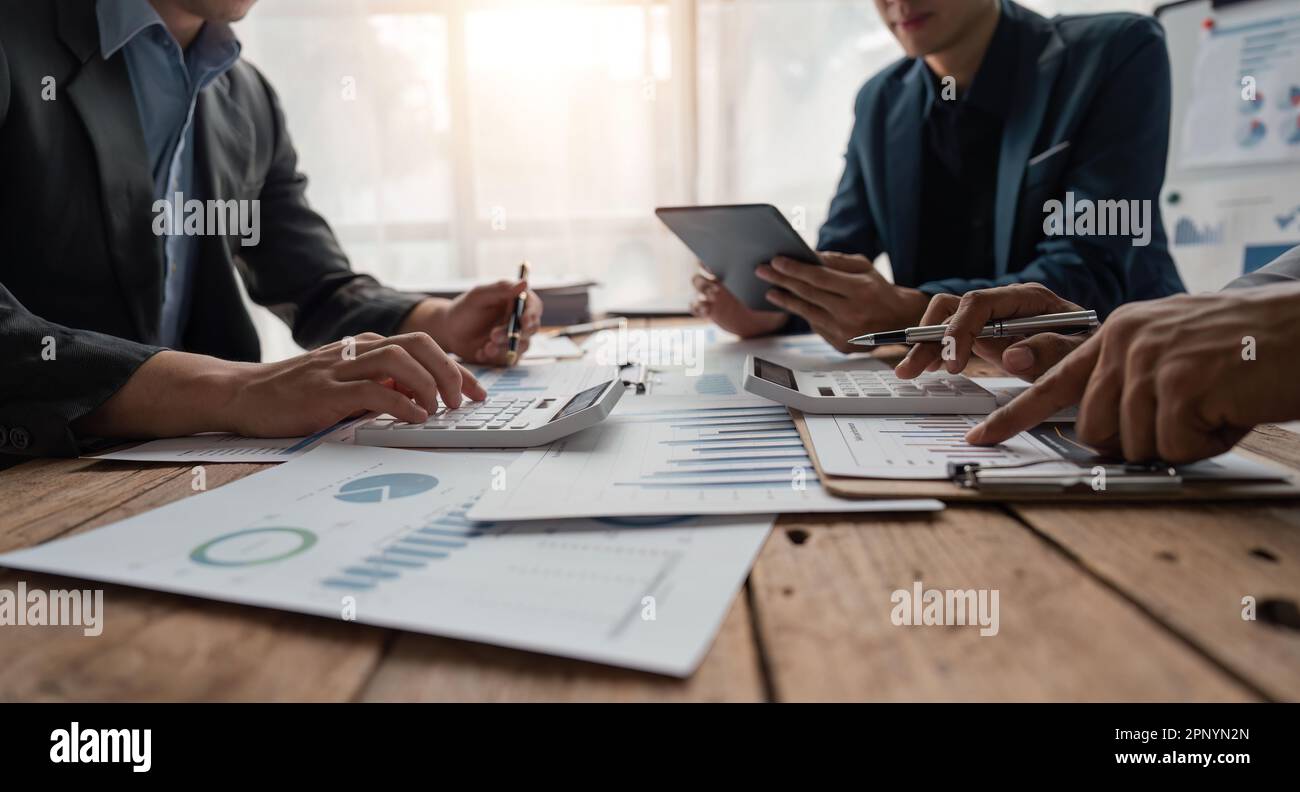 Team business using a calculator and tablet to calculate the numbers of ...