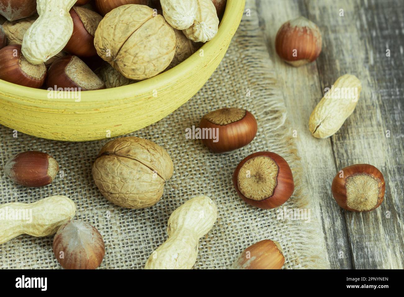 A mix of nuts in a shell, in a clay plate. A mixture of nuts on an old ...