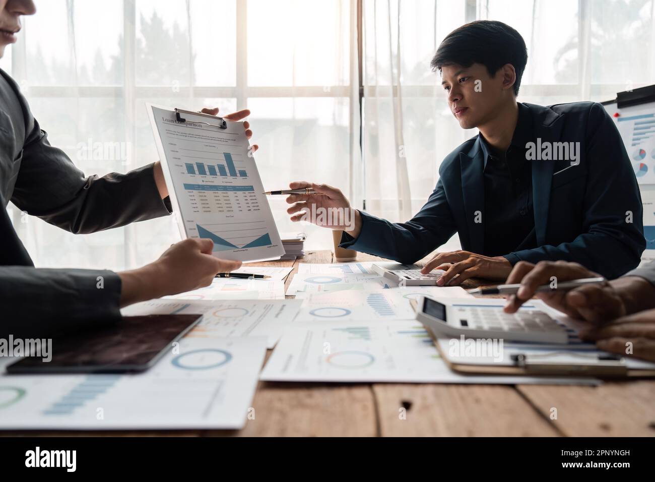 business team discussion of reports displayed in charts and graphs ...