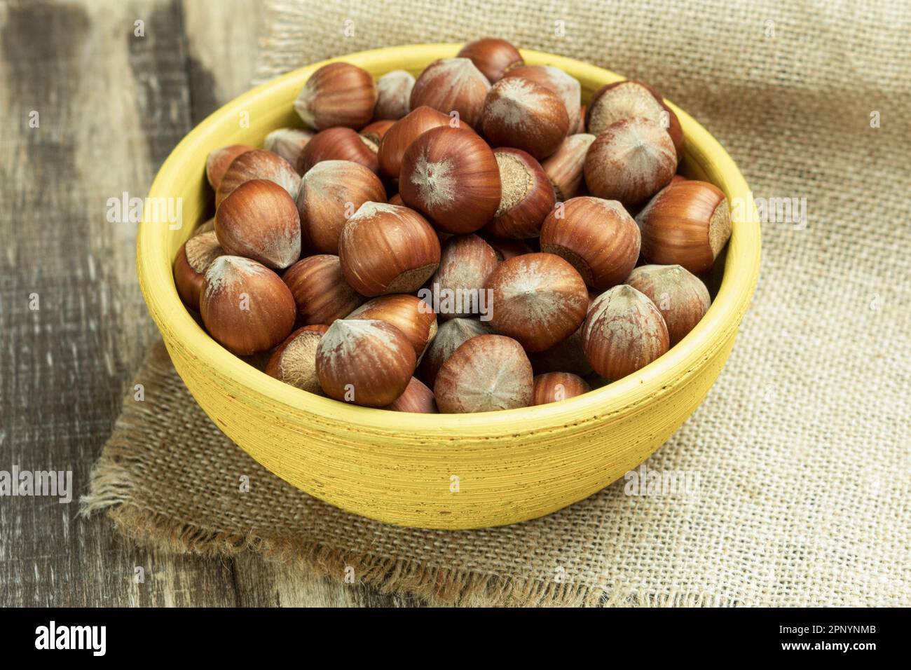 A mix of nuts in a shell, in a clay plate. A mixture of nuts on an old ...