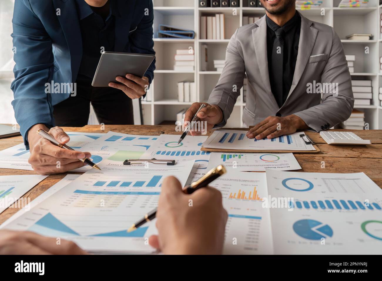 Team business using a calculator and tablet to calculate the numbers of ...