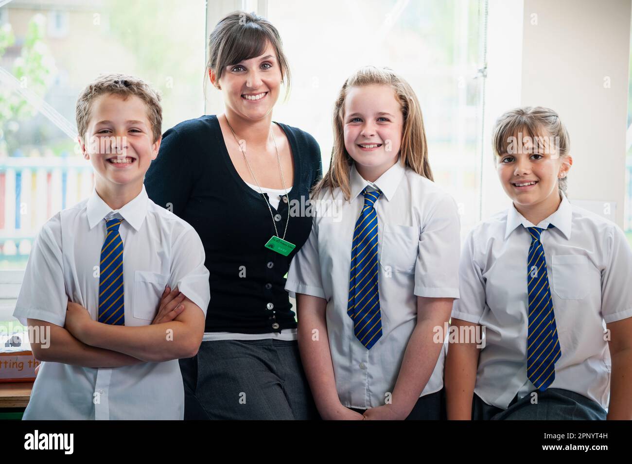 Teacher with three happy pupils in classroom Stock Photo - Alamy