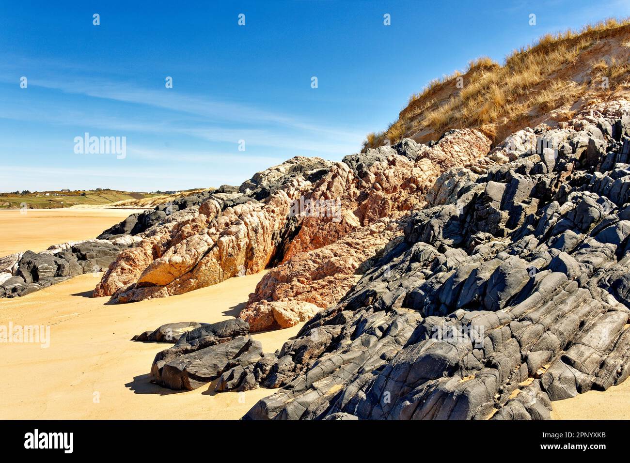 Torrisdale Bay Sutherland Scotland a blue sky an outcrop of volcanic ...