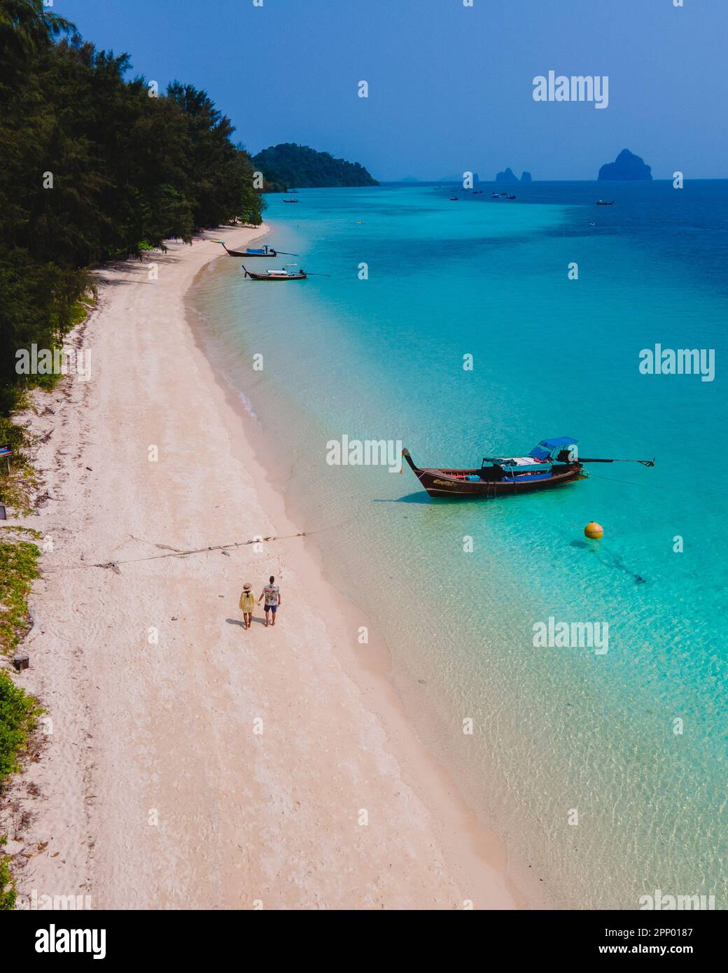 a couple walking on the beach of Koh Kradan Island with a white ...