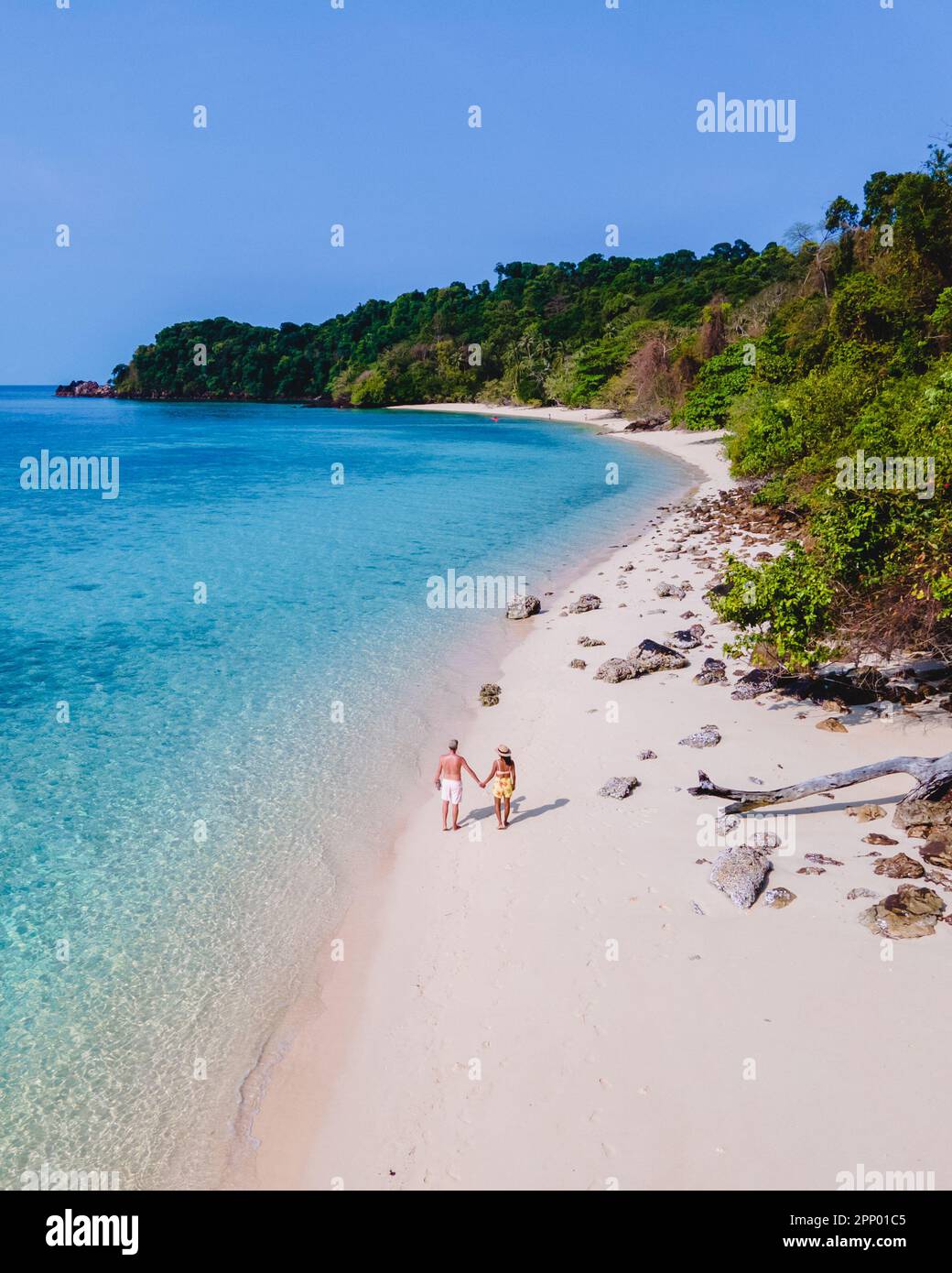 a couple walking on the beach of Koh Kradan Island with a white ...