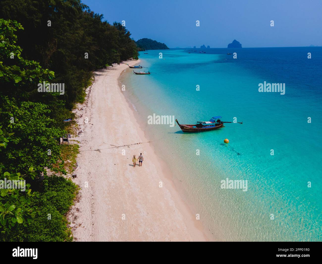 a couple walking on the beach of Koh Kradan Island, a tropical beach ...