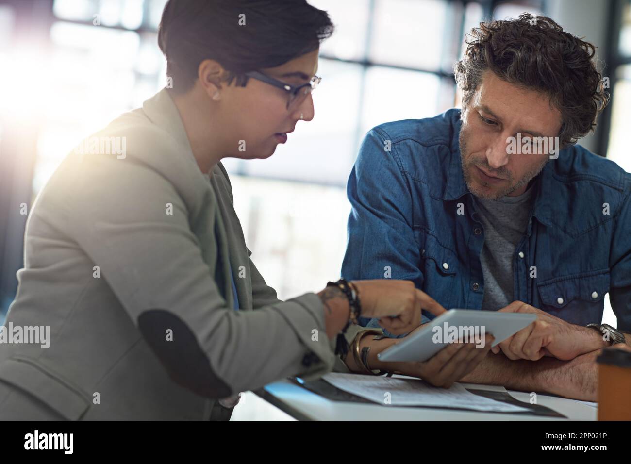 Preparing for their client pitch. two business colleagues meeting in ...