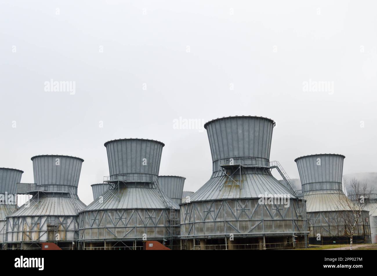 Large cooling towers in water and fog at an oil refinery, petrochemical ...