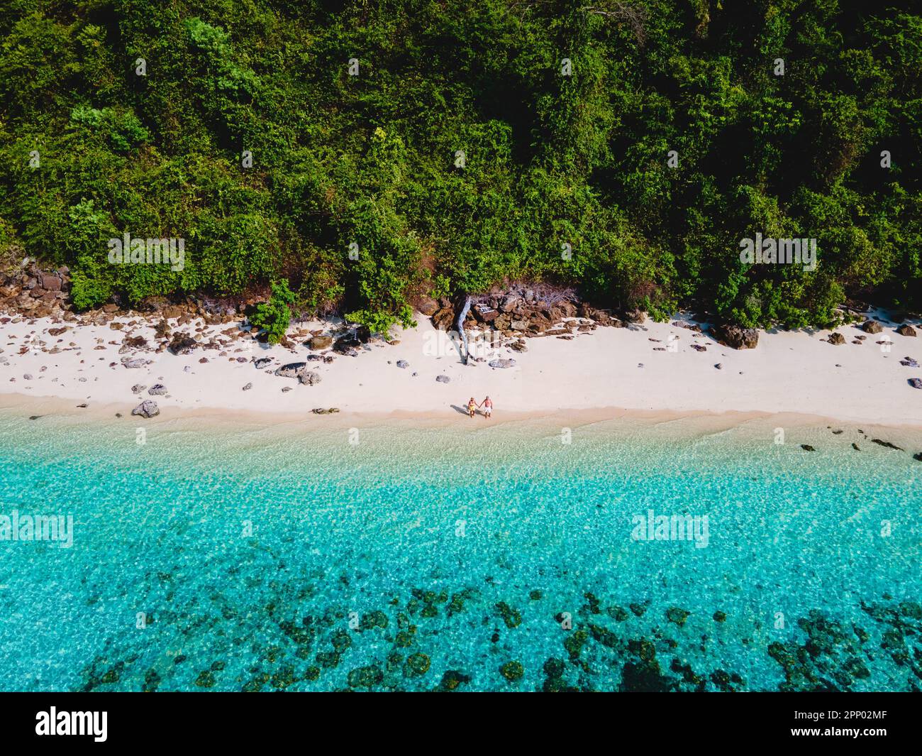 a couple walking on the beach of Koh Kradan Island, a tropical beach ...