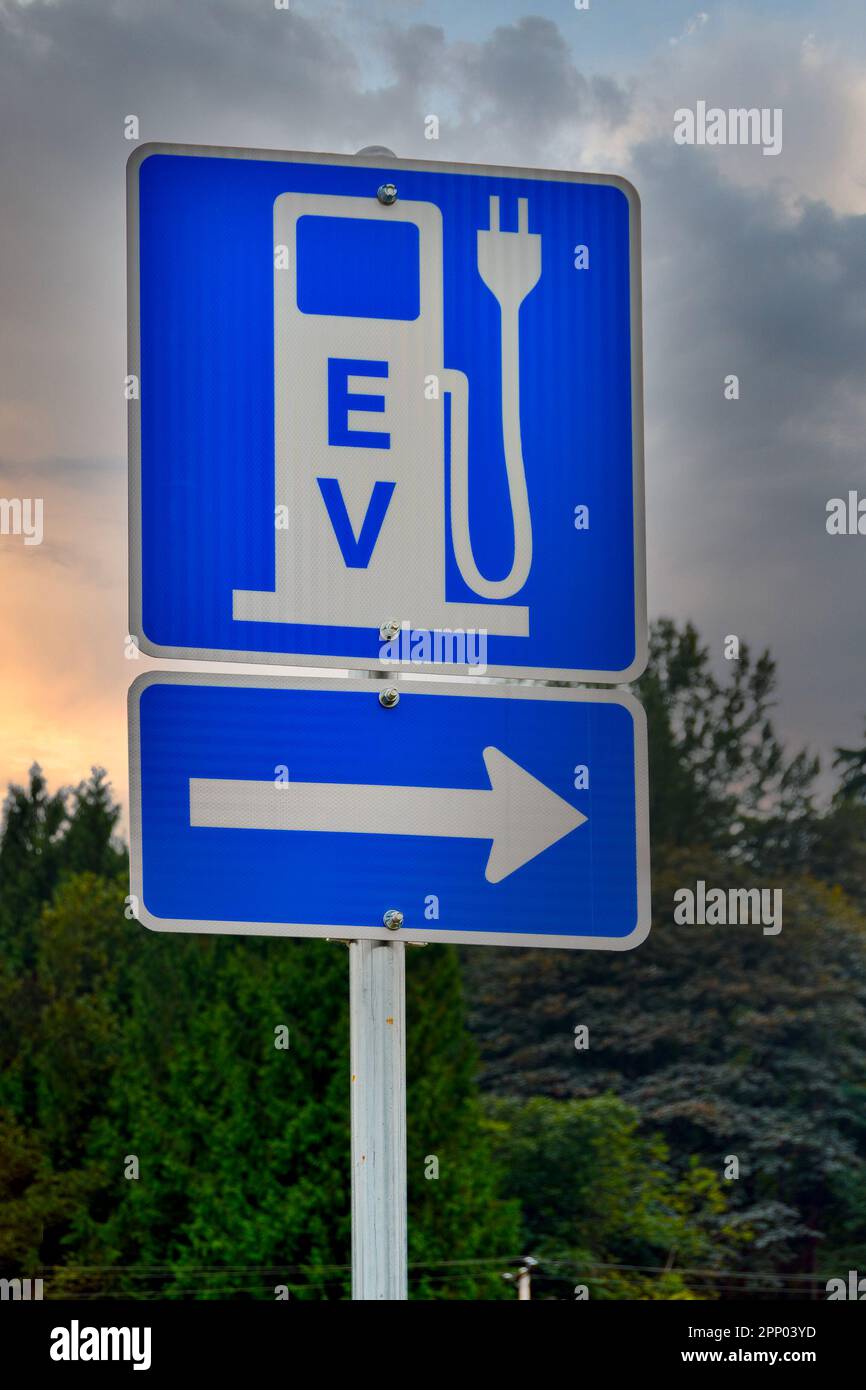 EV charging station road sign on dramatic sky background Stock Photo ...