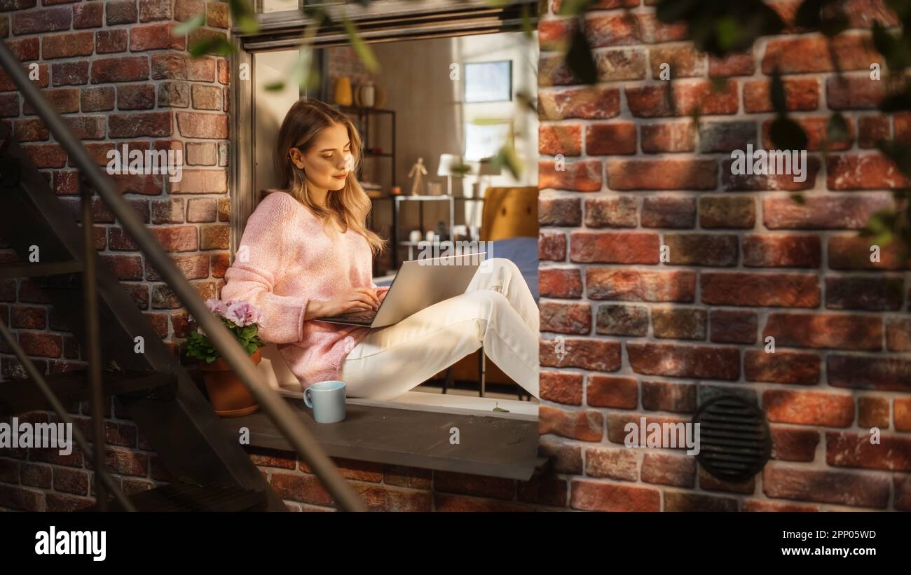 Beautiful Woman in Pink Sweater is Smiling, Typing on Laptop and ...