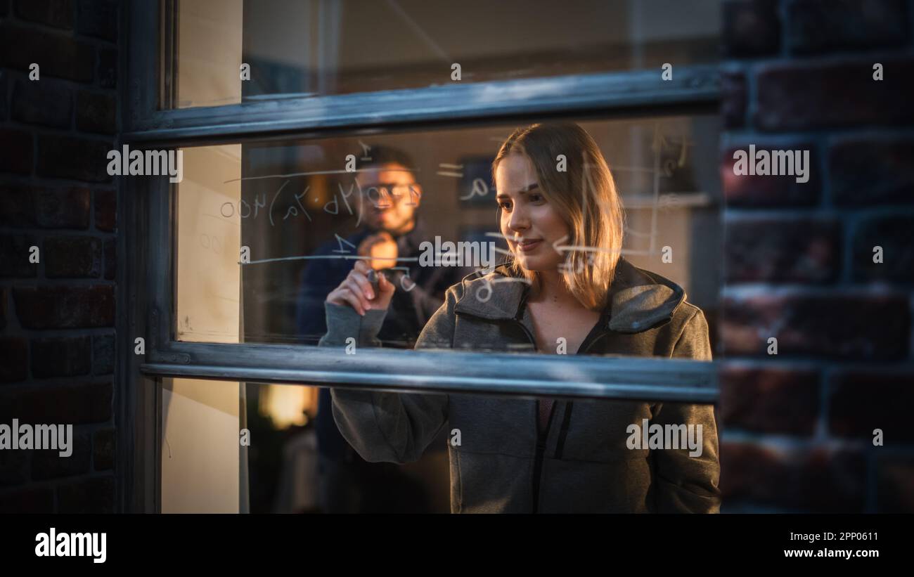 White Young Female Explaining a Math Equation on a Window at Home to a ...