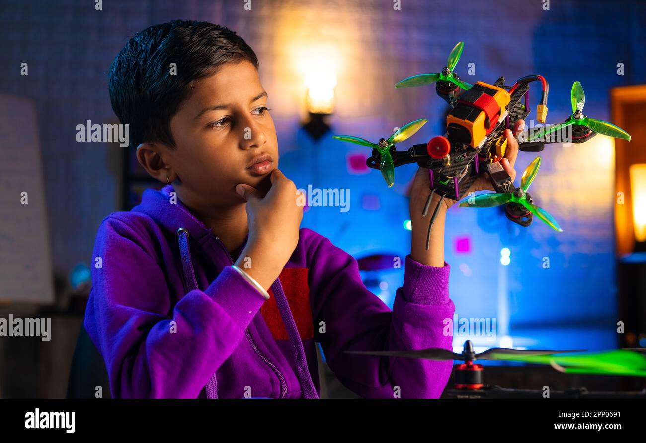 Young indian teenager kid thinking about drone flight at home during ...