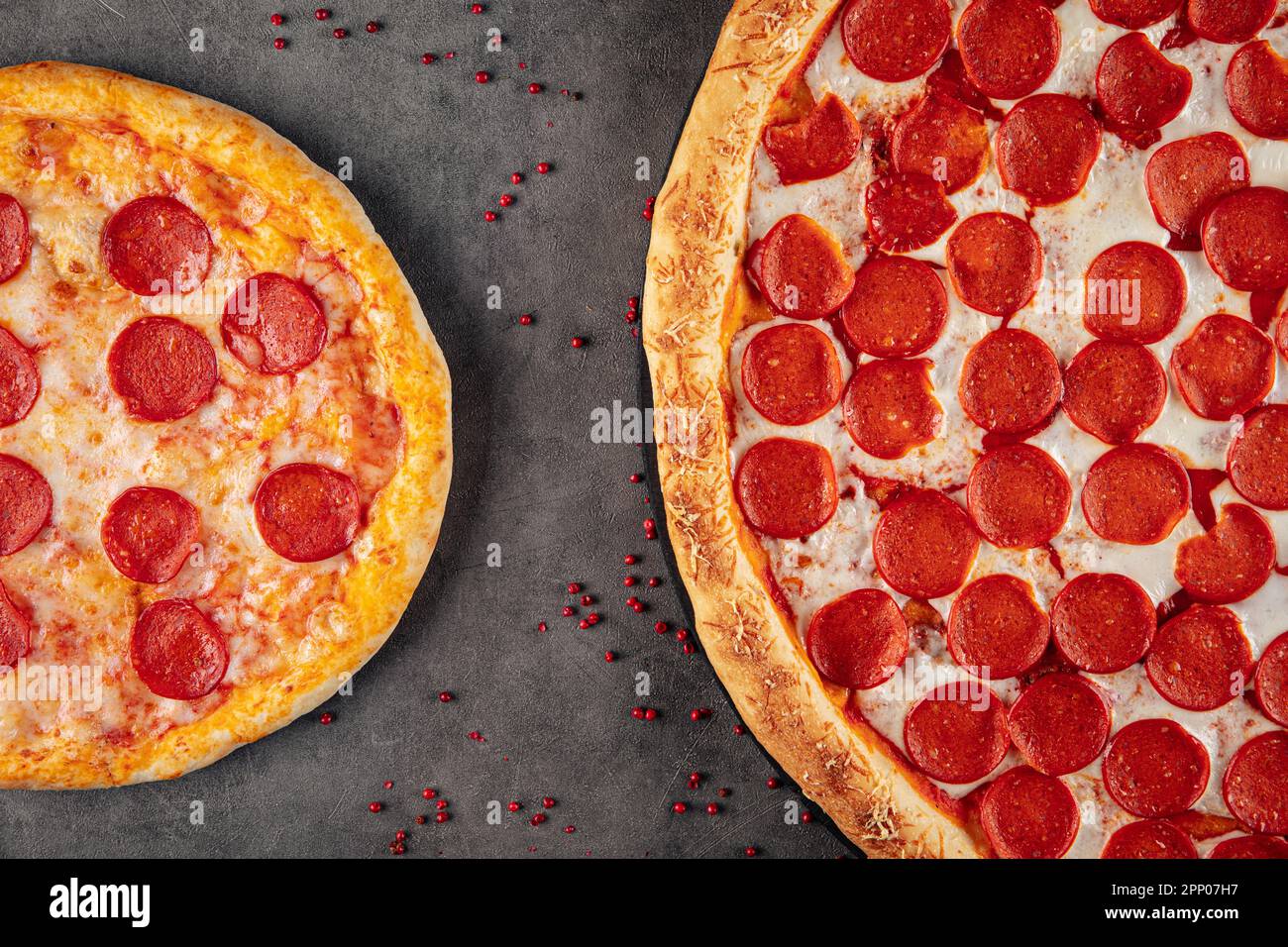 Side view on small and giant pepperoni pizzas Stock Photo - Alamy