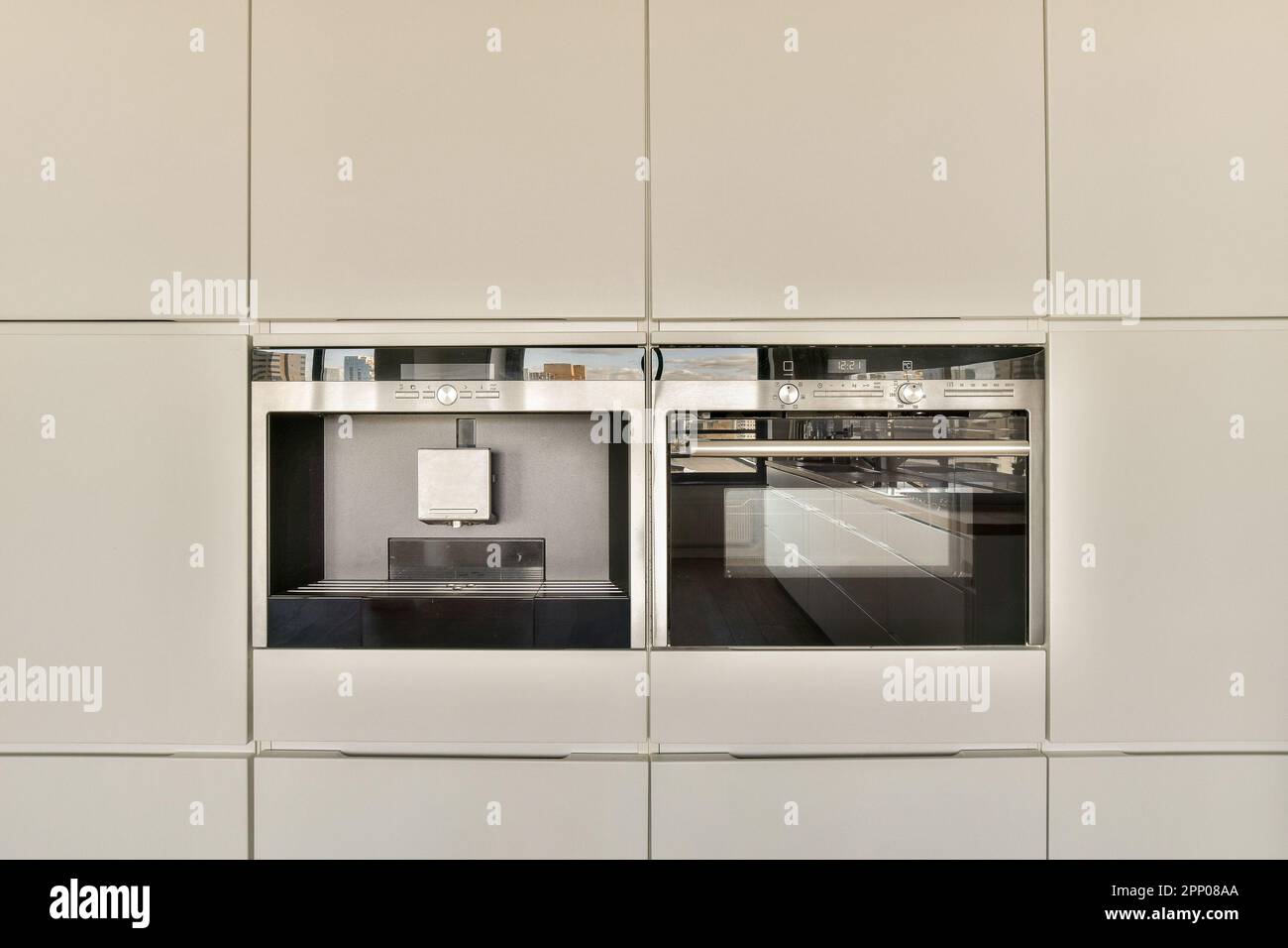 two ovens in a kitchen with white cabinets and black counter tops on ...