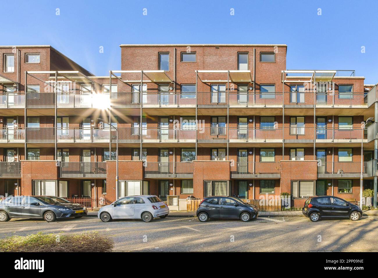 an apartment complex with cars parked in the parking lot and sun ...