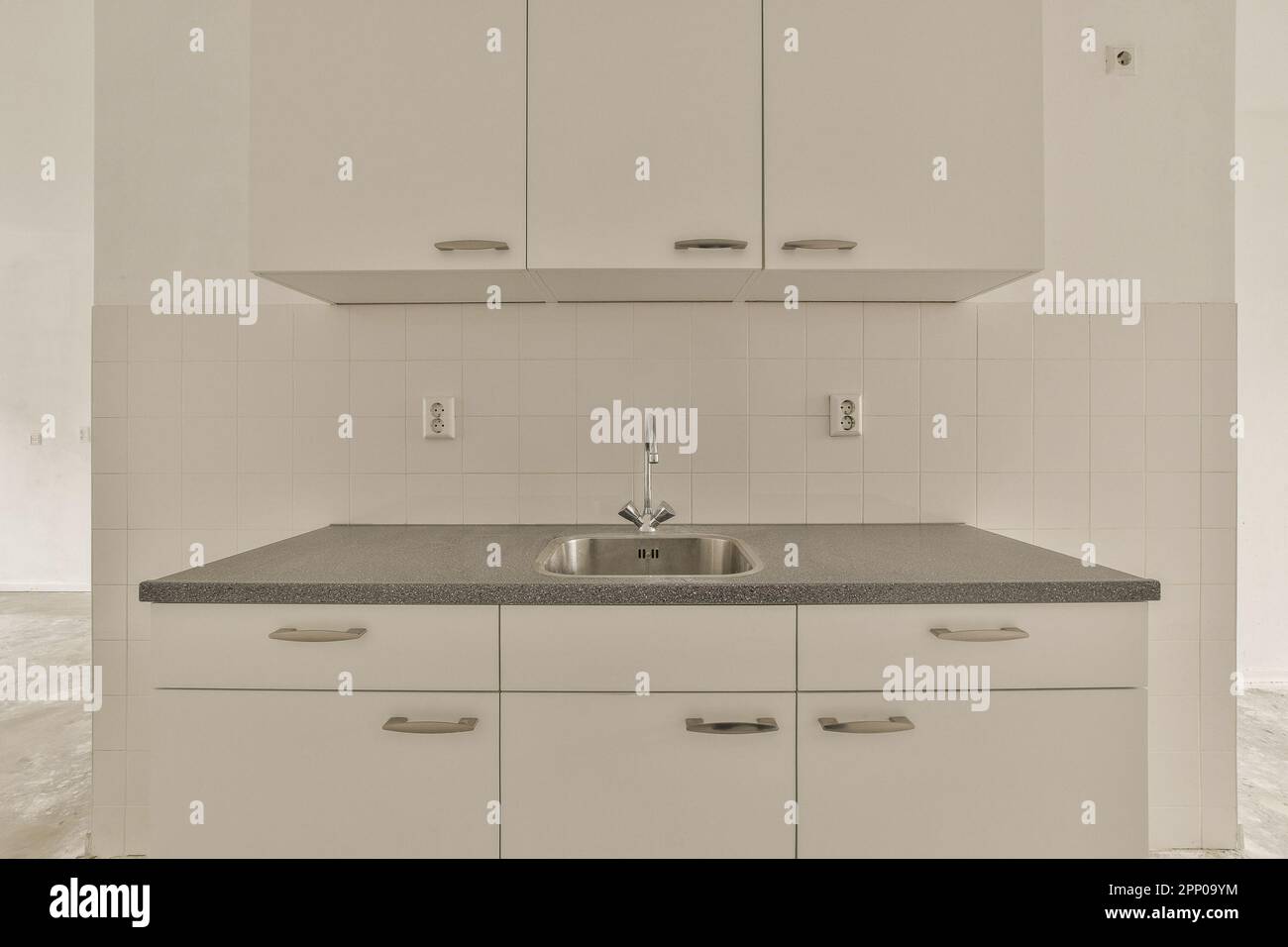 a kitchen with white cabinets and gray counter tops on the counters in ...
