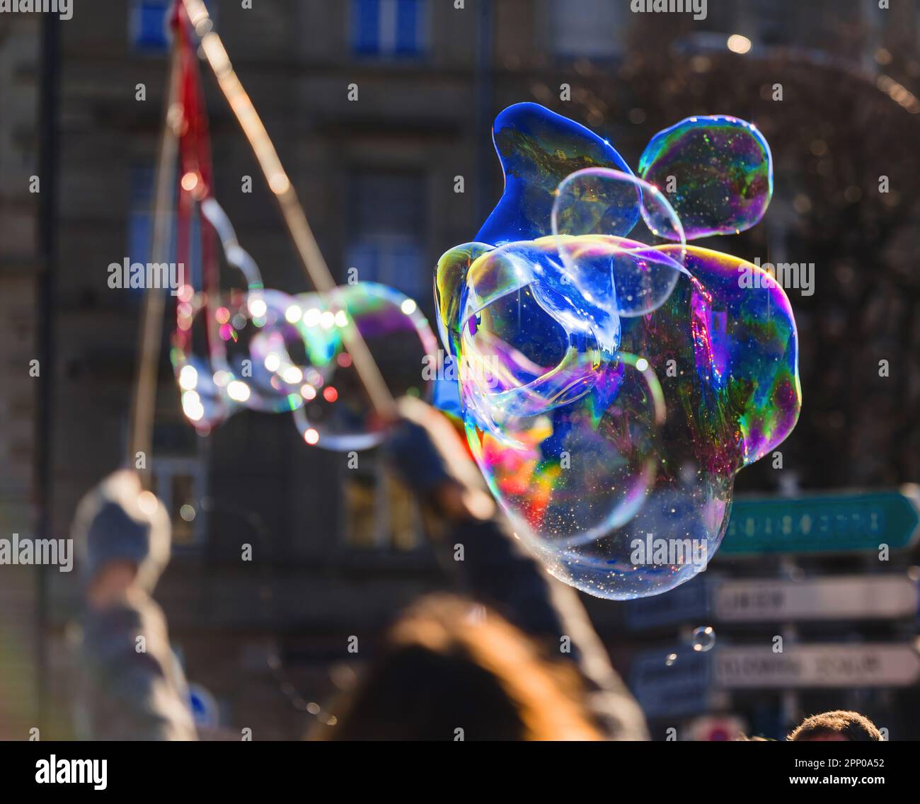Adult hands stands in mid-air, joyfully blowing multi colored liquid ...