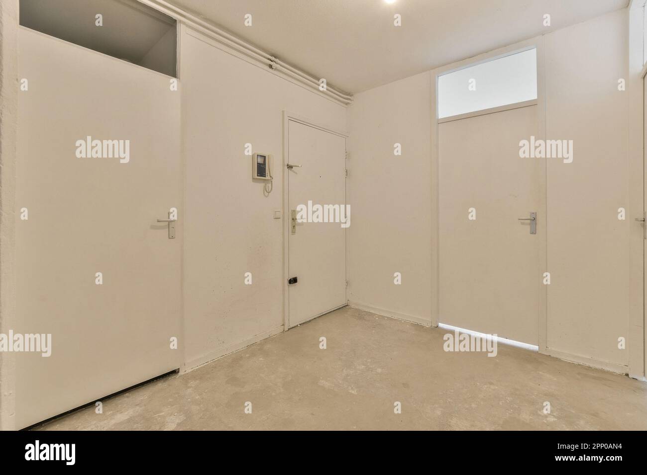 the inside of a room with white walls and two closed doors on each side ...