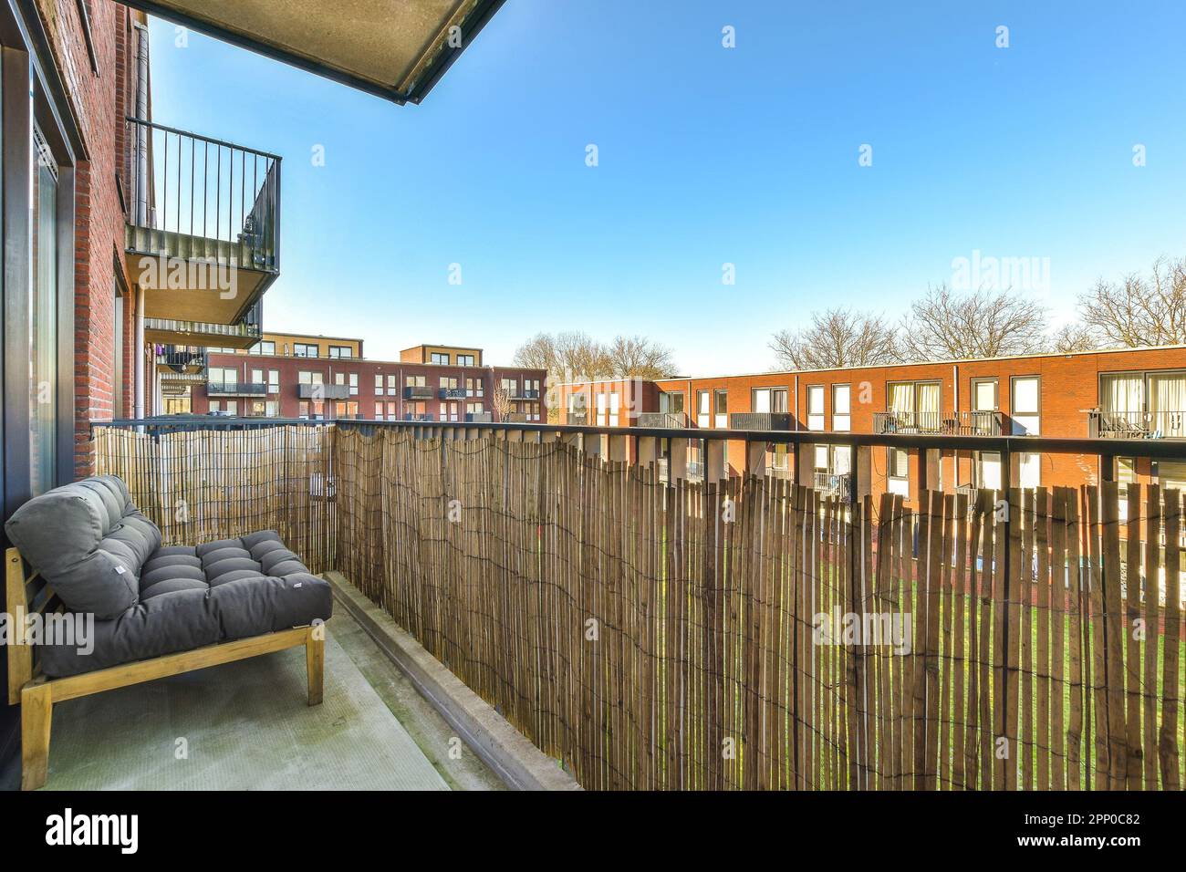 a balcony with a chair and some buildings in the background, taken from ...