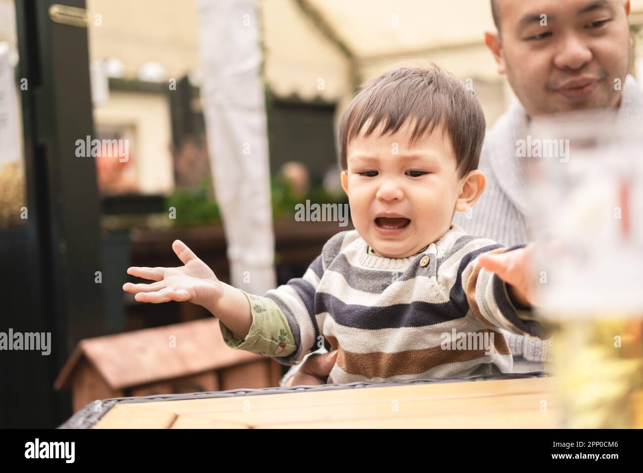 Upset male infant crying, screaming and raising his hands with open ...
