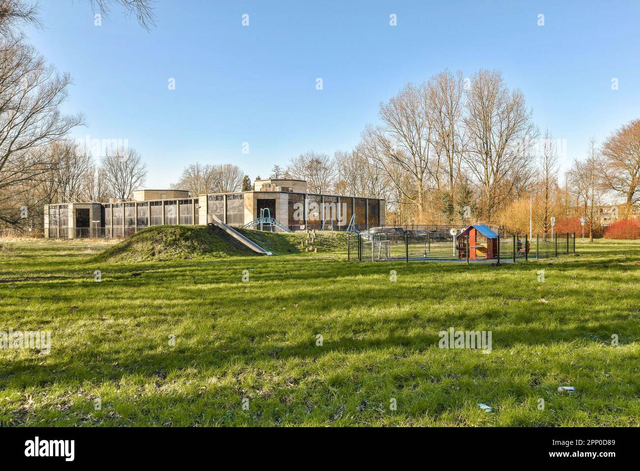 a house in the middle of an open field with trees and grass on both ...