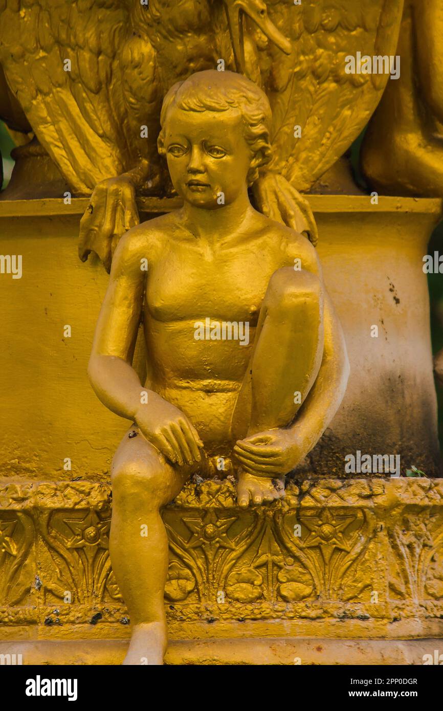 Golden boy statue on the fountain in the park Stock Photo - Alamy