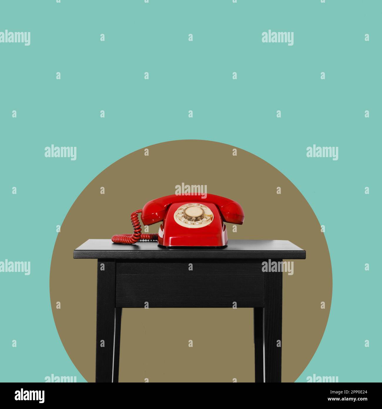 a red landline rotary dial telephone on a black table in front of an ...