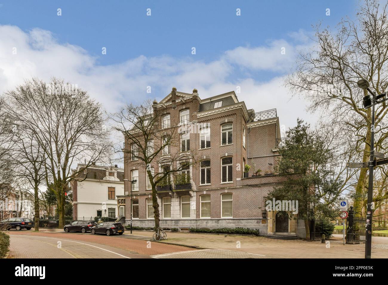 an old brick building in the middle of a street with trees and cars ...