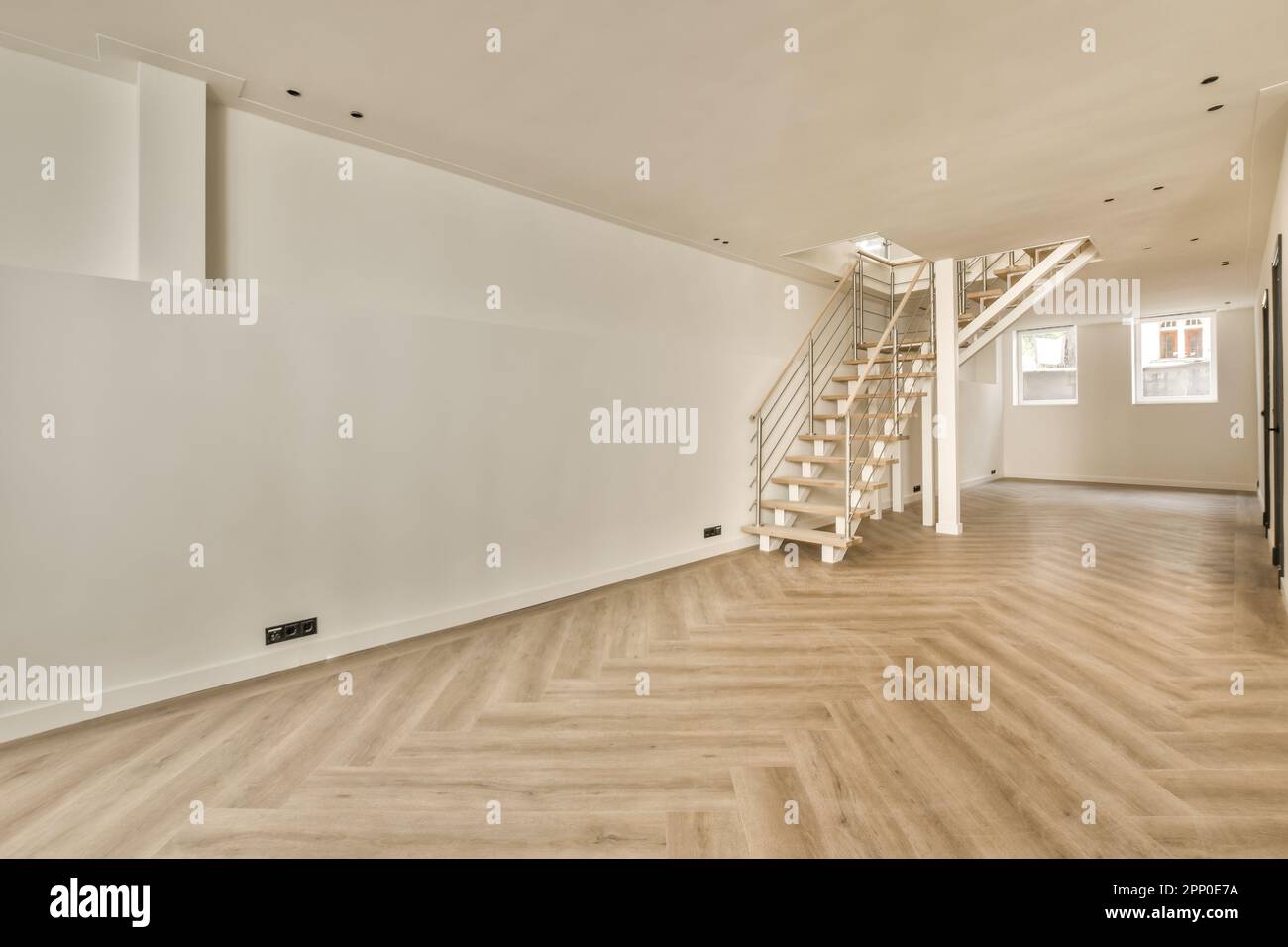 an empty living room with wood flooring and staircase leading up to the ...