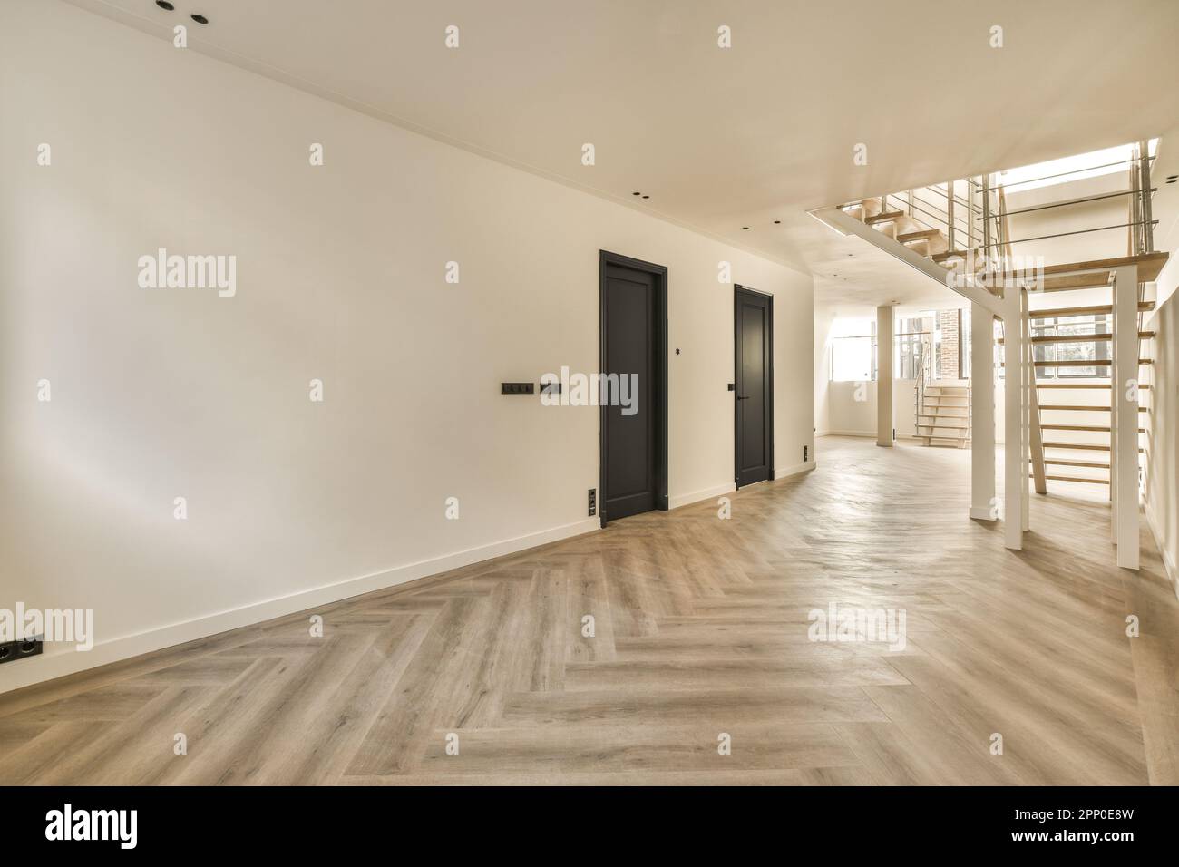 an empty room with wood flooring and staircase leading up to the second ...