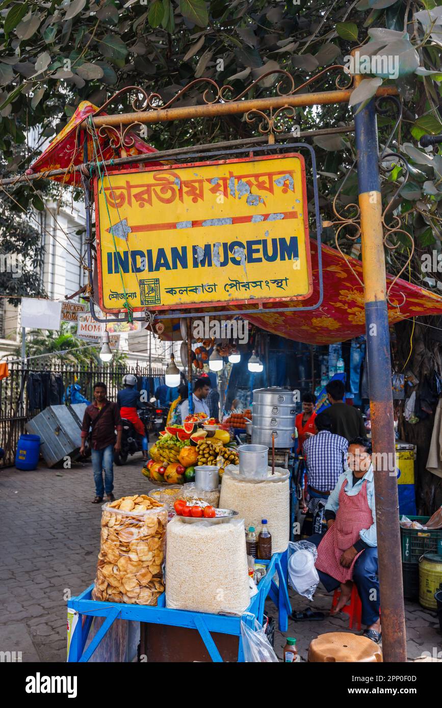 Name sign and street food stall seller by the entrance of the Indian ...